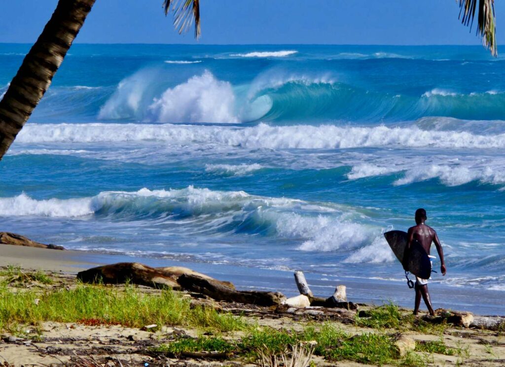 Joel Pimentel heads for a surf in the Dominican Republic during Idalia. Caribbean blue. PHOTO ...